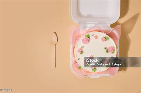 베이지색 배경에 흰색 선물 상자에 분홍색 크림 치즈 꽃으로 장식된 작은 한국 스타일의 트렌디한 도시락 케이크 사랑하는 사람을위한 선물로 케이크 여자를위한 봄 부드러운