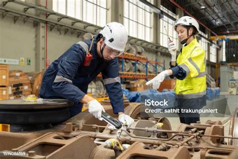 두 명의 전문 엔지니어가 아시아에서 리프트 전기 열차의 기계적 점검 하부 구조와 대중 교통 열차의 유지 보수를 점검합니다 2명에