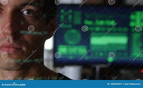 Portrait Of Man Programmer Hacker With Green Code Characters Reflect On His Face With A Computer