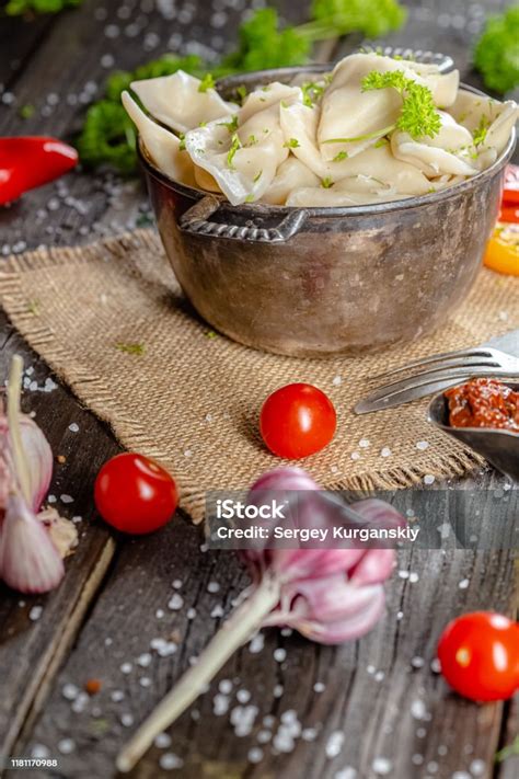 빈티지 소박한 그릇 접시 포크 나이프 숟가락 소금 향신료 신선한 허브 스탠드 와 거짓말 다른 각도 나무 절단 부엌 테이블에 어두운 빛에 빨간색과 흰색 생선 고기로 만든 만두