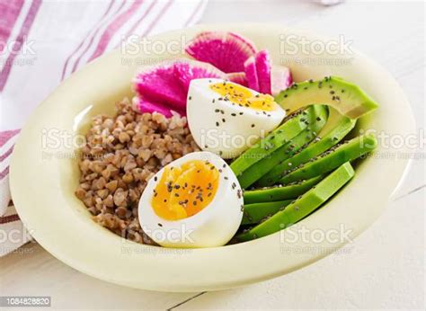 메 밀 죽 부처님 아보카도 삶은 계란 흰 테이블에 수 박 무와 그릇 건강 한 아침 식사입니다 0명에 대한 스톡 사진 및 기타 이미지 Istock