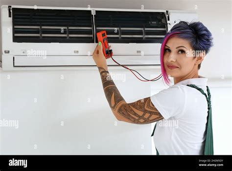 Female Electrician Measuring Voltage Of Air Conditioner In Room Stock Photo Alamy
