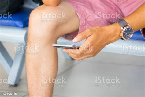 최신 유행 옷을 입고 영 돌 포장 석판의 배경에 남자와 벽돌 블러 젊은 Hipster 손에 휴대 전화를 닫습니다 젊은 남자는 모바일과 모바일 뱅킹 모습에 입력 검은색에 대한