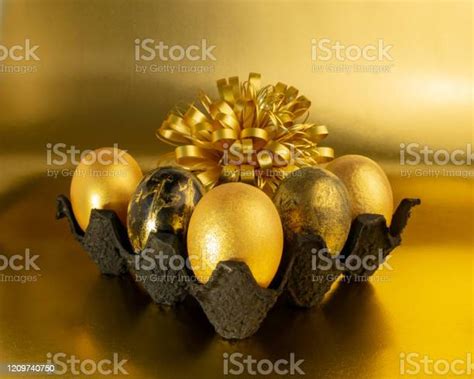 금색과 검은색으로 칠해진 다섯 개의 달걀은 반짝이는 배경에 어두운 질감의 스탠드에 놓여 있습니다 빛 부활절의 휴일 0명에 대한 스톡 사진 및 기타 이미지 Istock
