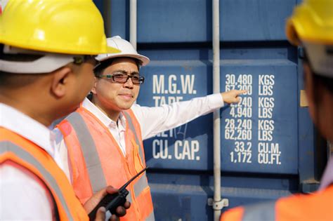 아시아 감독은 컨테이너의 다양한 구성 요소에 대한 새로운 교육 근로자를 새로운 검사 컨테이너 작업자에게 설명하고 가르치고 있습니다 연수생에 대한 스톡 사진 및 기타 이미지