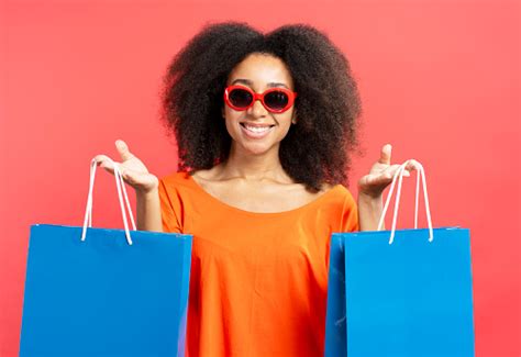 빨간 배경에 고립된 쇼핑백을 들고 선글라스를 끼고 웃는 여자 쇼핑 컨셉 25 29세에 대한 스톡 사진 및 기타 이미지 25