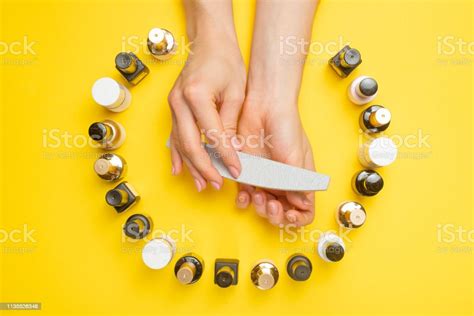 네일 아트의 개념입니다 여자는 테이블에 매니큐어를 만든다 매니큐어와 여성의 손에 노란색 배경에 젤 폴란드어 가위에 대한 스톡 사진 및 기타 이미지 Istock