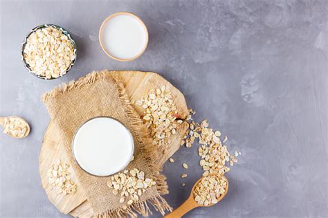 귀리 우유 나무 스탠드에 유기농 귀리 우유 귀리 플레이크가 있는 비건 비유제품 유기농 음료 시멘트 배경에 대체 우유 폐기물 제로 0명에 대한 스톡 사진 및 기타 이미지