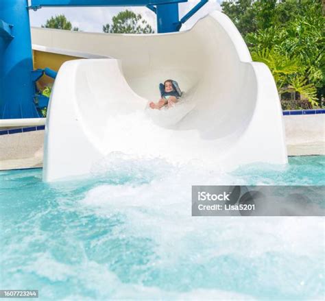 워터파크나 리조트 호텔의 소녀가 워터 슬라이드를 타고 수영장으로 미끄러져 내려간다 워터 슬라이드에 대한 스톡 사진 및 기타 이미지 워터 슬라이드 물이 튀는 4 5세