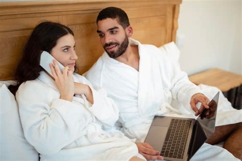 Premium Photo Husband Showing Laptop To Wife While Talking On Phone