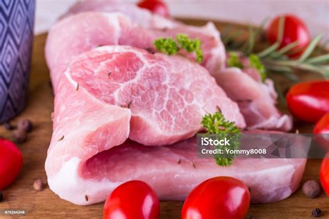 가로 사진 가장자리에 지방으로 돼지고기의 몇 길고 얇은 조각으로 녹색 파 슬 리 잔 가지와 토마토와 함께 단일 로즈마리 고기 옆에 있습니다 날 음식 나무도 마에입니다 0명에