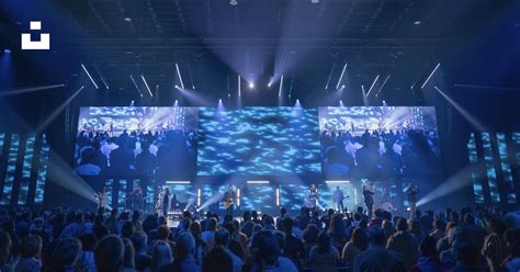 조명이 있는 무대에 있는 한 무리의 사람들과 군중이 지켜보고 있습니다 사진 Unsplash의 무료 파랑 이미지