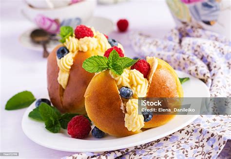 휘핑 크림과 신선한 라즈베리 블루 베리로 장식 된 럼 바바 럼주 크림 베리를 곁들인 사바린 이탈리아 요리 0명에 대한 스톡 사진