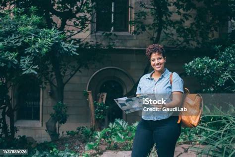 배낭과 종이 지도를 들고 세계를 탐험하기 위한 여행 휴가를 즐기는 쾌활한 여성 관광객의 절반 길이 초상화 도시 공원에서 카메라를 향해 웃고 있는 위치 종이를 가진 행복한