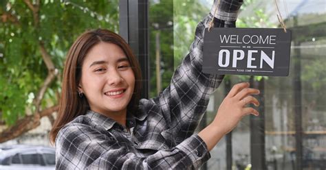 친절한 웨이트리스 여자가 문 유리에 열린 표지판을 매달고 있습니다 사진 Unsplash의 태국 이미지