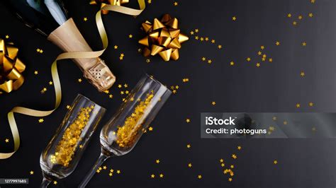 크리스마스 샴페인 병과 검은 배경에 반짝이는 색종이와 황금 장식이있는 안경을 마십니다 플랫 레이 상단 보기 Xmas 파티 새해 전야 축하 개념 0명에 대한 스톡 사진 및