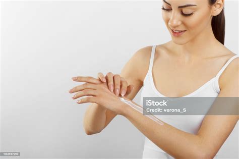 손 피부 관리 크림 로션을 적용 하 여 여성의 손의 클로즈업 빨간 매니큐어와 아름 다운 여자 손 손톱은 부드러운 매끄러운 건강 한 피부에 화장품 핸드 크림을 적용 합니다