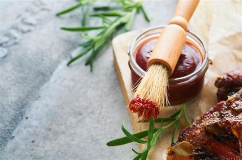 Premium Photo Hot And Spicy Barbecue Sauce In Jar Bowl With Basting Brush On Old Stone Gray