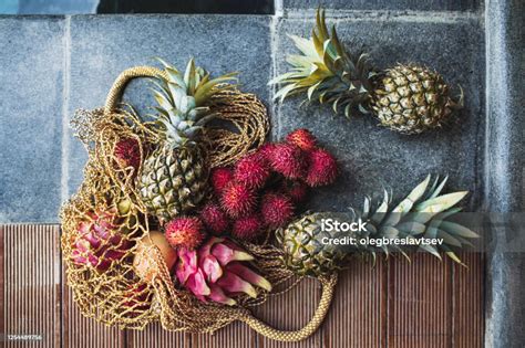 신선한 열대 과일 파인애플 람부탄 드래곤 과일을 재사용 가능한 메쉬 백에 넣은 플랫 레이 제로 폐기물 라이프 스타일 원시 건강 식품과 채식주의 식단 여름의 맛 가방에 대한