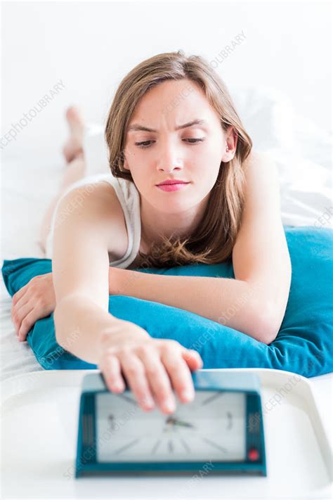 Woman Turning Off Alarm Clock Stock Image C034 7514 Science Photo Library