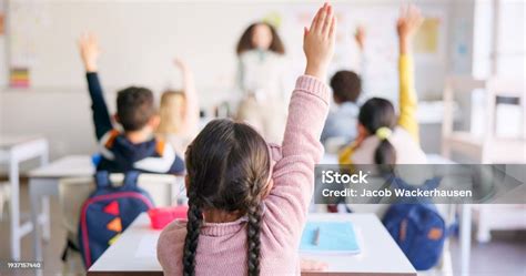 교육 학습 토론 및 지식을 위해 교사와 함께 교실에서 손을 들고 여학생 여성 교육자 또는 학교 교사에게 질문이 있는 학생 공부 및 어린이 학생을 돕습니다 교실에 대한 스톡