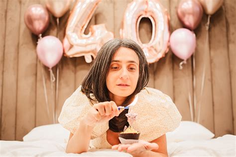 성인 행복 아름 다운 여자 사십 년 촛불을 손에 촛불 축제 컵 케이크와 함께 흰색 생일 소녀에 고립 자연스러운 성숙한 여자 생일 축하 생일 축하 컵케이크 촛불 1개를 켜세요