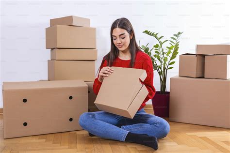 젊은 여자는 상자를 포장하고 새 아파트로 이사합니다 새로운 장소를 옮기는 젊은 여성과 수리 개념 바닥에 앉아 많은 판지