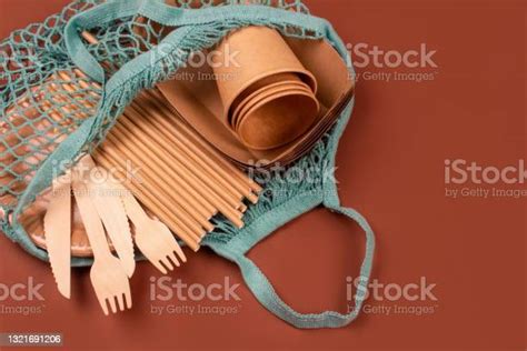 크래프트 종이 식품 컵과 텍스트 복사 공간이있는 갈색 배경에 파란색 면 그물 가방에 나무 칼붙이 용기 친환경 식기 길거리 음식은