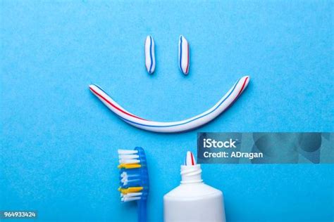 미소는 얼굴의 형태로 치아 붙여넣기 파란색 배경에 칫 솔 및 치약의 튜브입니다 상쾌하 고 치약 미 백입니다 이빨에 대한 스톡