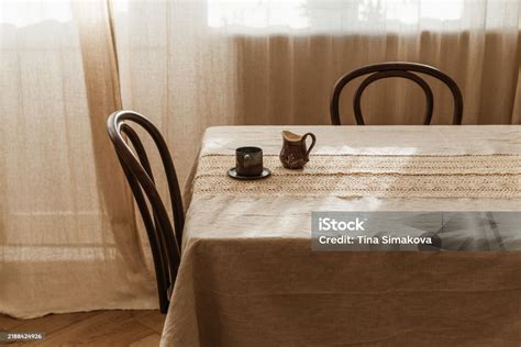 차 또는 커피 한 잔과 우유 주전자를 곁들인 1인용 우아한 아침 식사는 레이스가 달린 린넨 식탁보로 덮인 테이블 위에 서서 시골집의 따뜻하고 화창한 여름날을 보냅니다 0명에