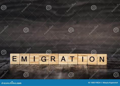 The Word Emigration Is Made Of Bright Wood Cubes With Black Letters On