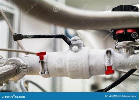 Frozen Liquid Nitrogen Carrying Pipes With A Valve And Black Plastic Lever Close Up In A Science