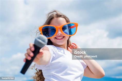 라이프 스타일과 사람들의 개념 목소리를 더 크게 만드십시오 마이크와 함께 노래를 부르는 십 대 소녀 파티를 가진다 마이크를 가진 행복 한 아이입니다 노래방 개념입니다 노래