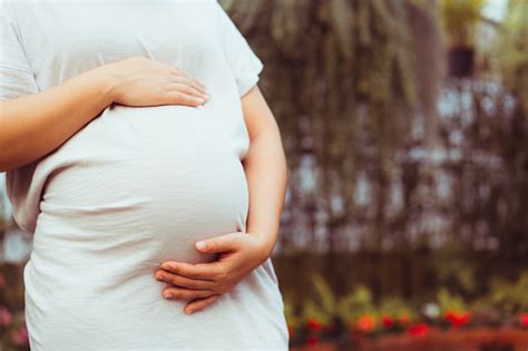 임신 한 여자는 그녀의 아이를 돌보는 동안 집에서 행복을 느낀다 임신 한 배에 아기를 들고 젊은 기대 어머니 출산 전 관리 및