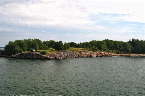 물로 둘러싸인 나무가 있는 바위 섬 수역에 있는 숲이 우거진 섬 나무와 바위가 있는 섬의 풍경 나무가 우거진 작은 섬의 물 전망 푸른 나무와 바위가 많은 해안이있는 섬 0