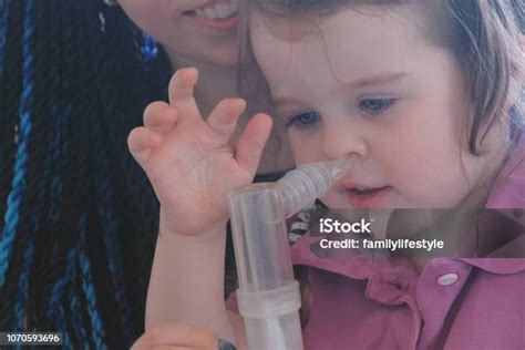 그녀의 엄마와 함께 흡입기 마스크를 통해 흡입 작은 귀여운 소녀 분무기 및 흡입기를 사용 하 여 치료에 대 한 건강관리와 의술에