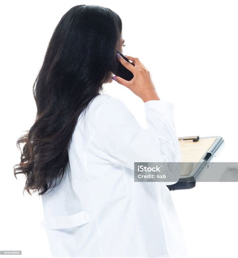 라틴 아메리카와 히스패닉 인종 젊은 여성 의사는 실험실 코트를 입고 서류를 들고 휴대 전화를 사용하여 흰색 배경 앞에 서 20 24세에 대한 스톡 사진 및 기타 이미지