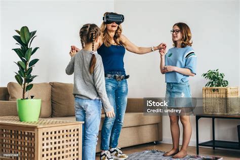 아이 들과 함께 거실에 서 있는 가정에서 Vr 헤드셋 안경 가상 현실을 사용 하 여 여자 3차원 형태에 대한 스톡 사진 및 기타 이미지 3차원 형태 가상현실 가상현실