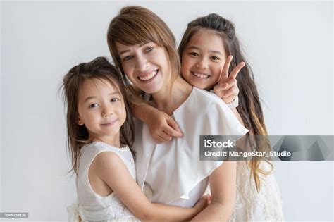 행복 한 백인 여자 딸 널리 웃 고 시간을 함께 즐기고 함께 예쁜 다민족 여자 보여주는 평화 서명 포옹 어머니 여동생 근처에 서