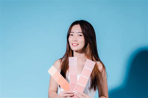 매력적인 아시아 뷰티 우먼은 파란색 배경에 자외선 차단 Uv 또는 자외선 차단제로 선크림과 컬러 스케일을 들고 있습니다 18 19세에 대한 스톡 사진 및 기타 이미지