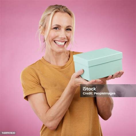 스튜디오에 있는 여성의 선물 상자 초상화 미소 분홍색 배경 패키지 행복한 여성 모델 생일 축하를 위한 선물 및 서프라이즈 흥분된 경품 및 거래를 축하하기 위한 프로모션