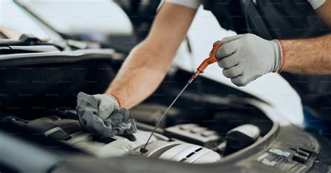 수리점에서 모터 오일을 확인하는 자동차 정비사의 클로즈업 사진 Unsplash의 차고 이미지