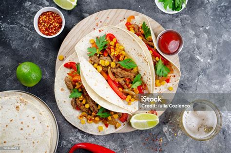 쇠고기와 야채를 곁들인 멕시코 타코 어두운 배경에 있는 타코 알 목사 거리에 대한 스톡 사진 및 기타 이미지 거리 고기 노랑 Istock