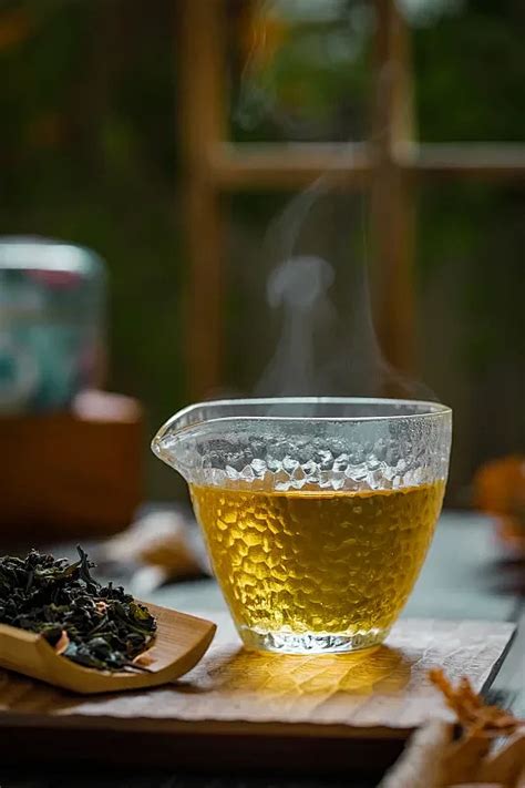 放在木盘上热气升腾的一杯热乌龙茶图片下载