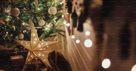 세련된 크리스마스 스타 흰색 싸구려가 있는 나무 보호 장식품 황금 조명 및 분위기 있는 저녁 방의 선물 이브의 축제 스칸디나비아 방 마법의 시간 텍스트를 위한