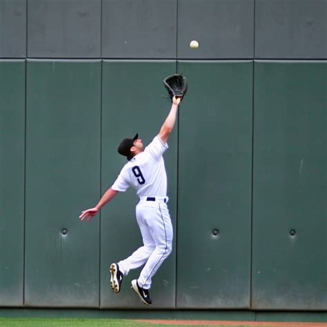 A Baseball Player Jumps To Catch A Ball Premium Ai Generated Image