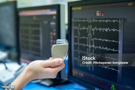 Doctor Hand Hold Pacemaker Device With Screen Of Ekg Monitoring
