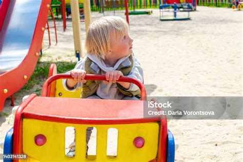귀여운 재미 금발 작은 어린 유아 아이 소년 앉아서 장난감 자동차 놀이터에서 자동차에 타고 어린이 신체적 정서적 발달 및 어린 시절의 보육 유치원 개념 2 3 살에 대한
