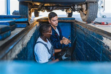 자동차 수리 점에서 남성 및 여성 자동차 정비사 직원 확인 수리 및 유지 보수 휠 교육에 대한 스톡 사진 및 기타 이미지 교육 수리공 신규 사업 Istock