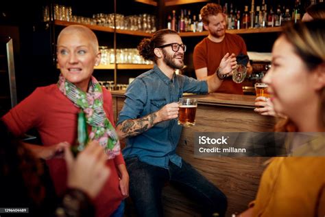술집 카운터 근처에 서서 맥주를 마시고 채팅을 하는 쾌활한 친구들 30 39세에 대한 스톡 사진 및 기타 이미지 30 39세 나이트클럽 남자 Istock
